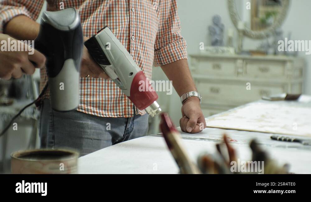 Masters in the art studio process the tree with a construction hair dryer Stock Video Footage ...