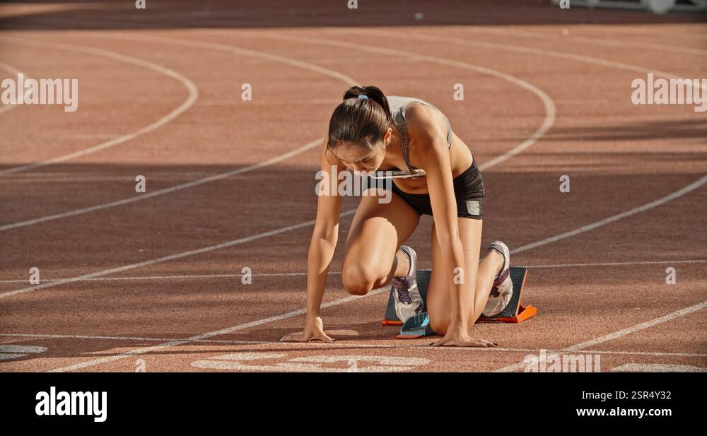 Female runner on track. Young asian athlete standing on starting line ...
