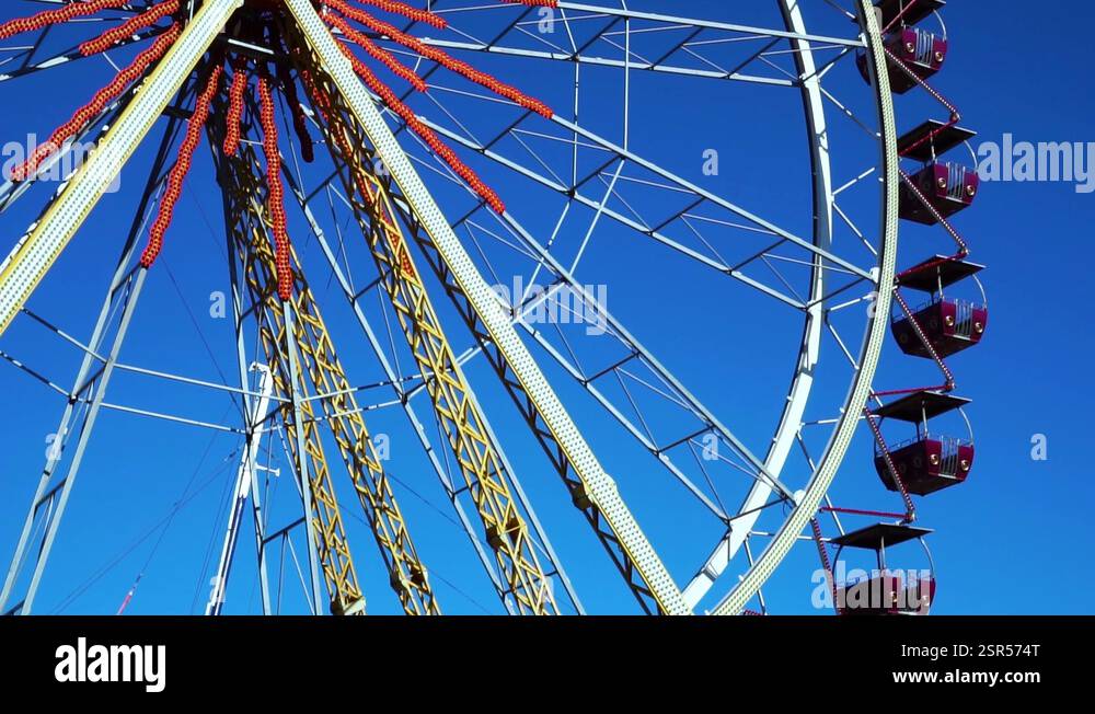 Enormous colorful ferris wheel fun roller coaster ride spinning slowly ...