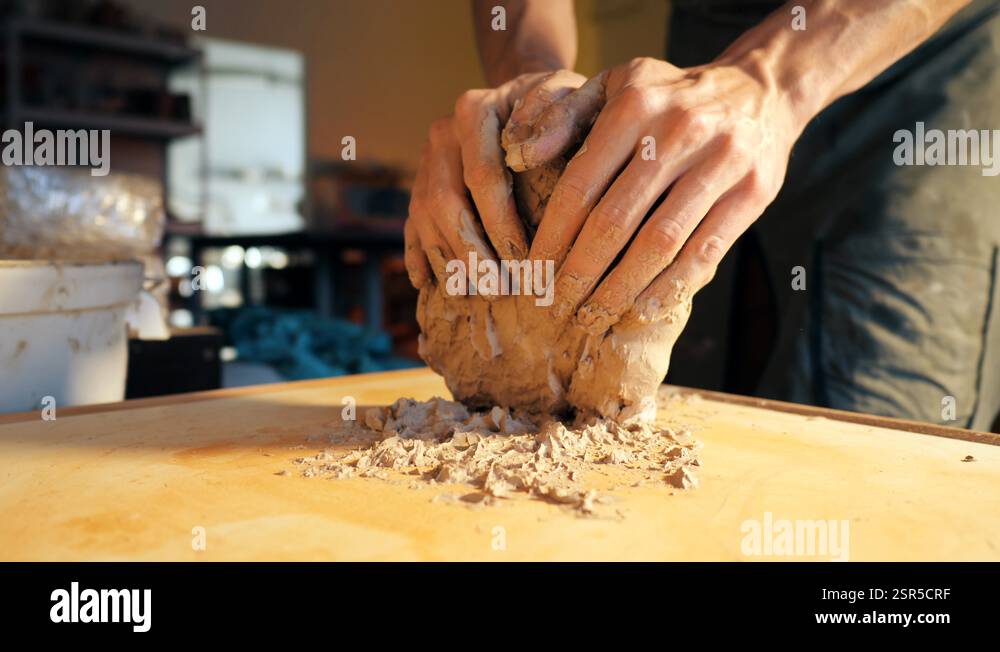 Artisan potter prepares material clay for pottery. Man knead clay ...