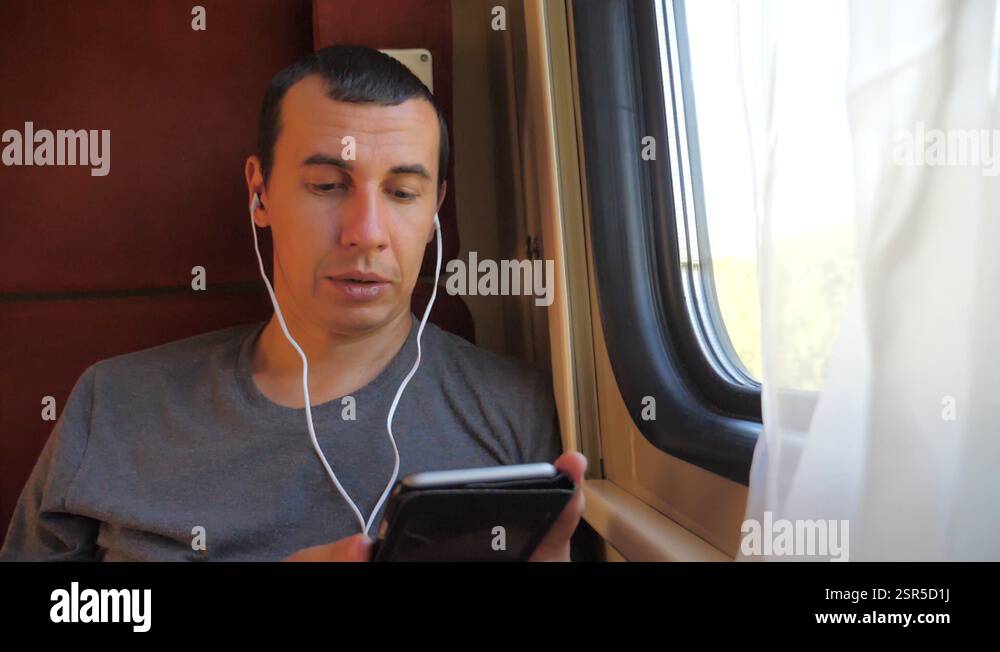 man listening to the music on the train rail car coupe compartment ...