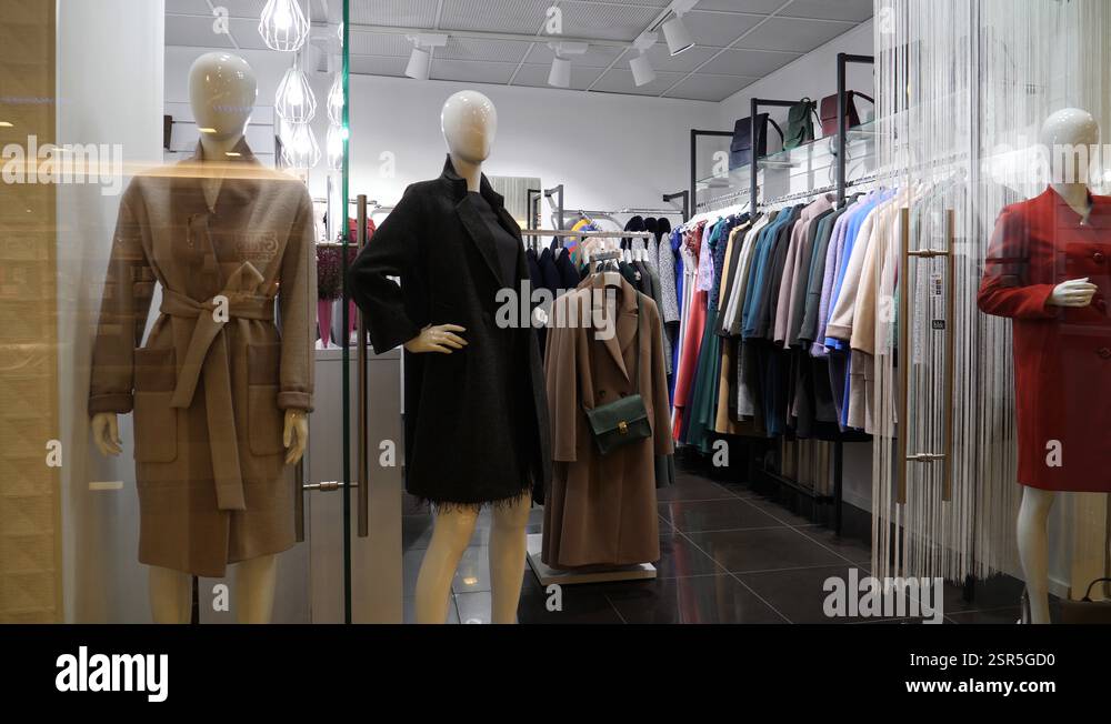 Coats and dress boutique store interior in a shopping mall center with ...