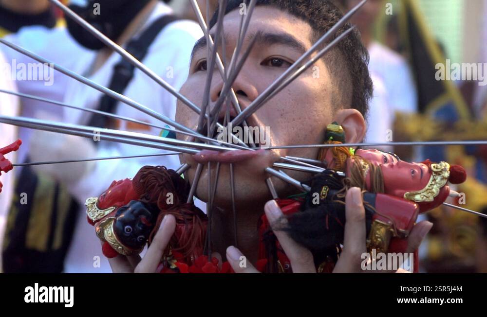 A follower of the Chinese Shrine, pierces cheeks with skewers Stock ...