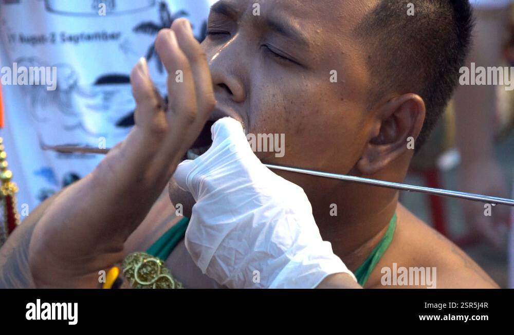 A follower of the Chinese Shrine, pierces cheeks with skewers Stock ...