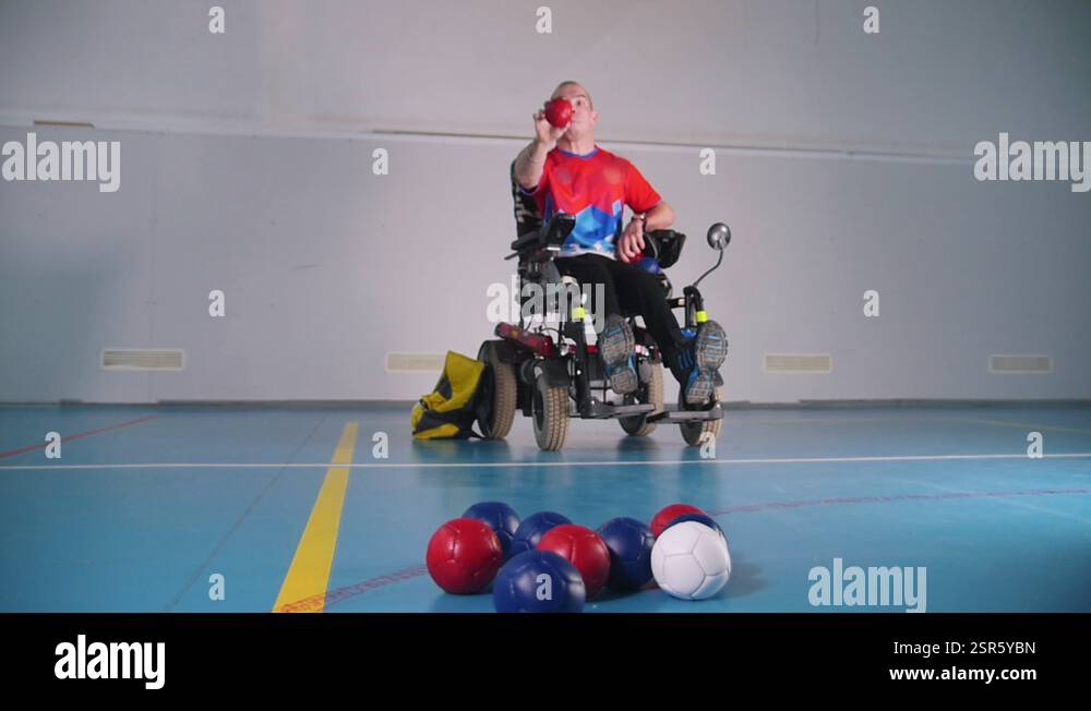 A disabled man in a wheelchair. Throwing a blue little ball. Boccia ...