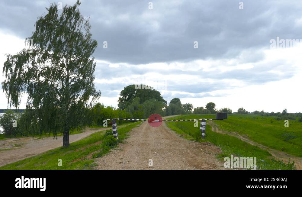 Long shot of a No entry sign and a road block on a dirt country road ...