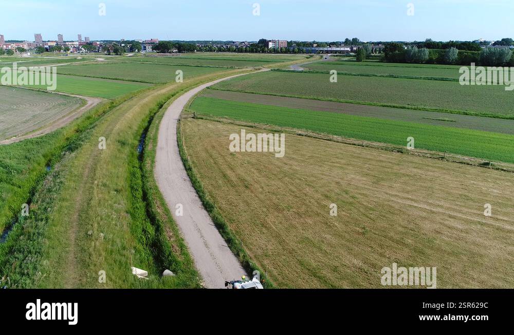 Static aerial footage of tractor driving over narrow rural road 4k ...