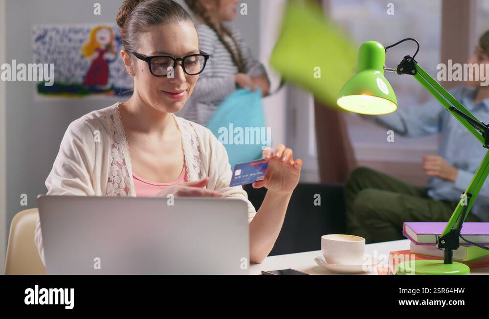 Young mother ordering goods using a laptop and a credit card Stock ...