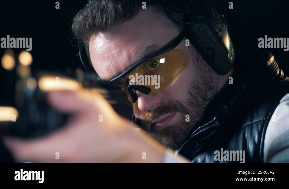 A man is aiming from a rifle with his face being in a close up Stock ...