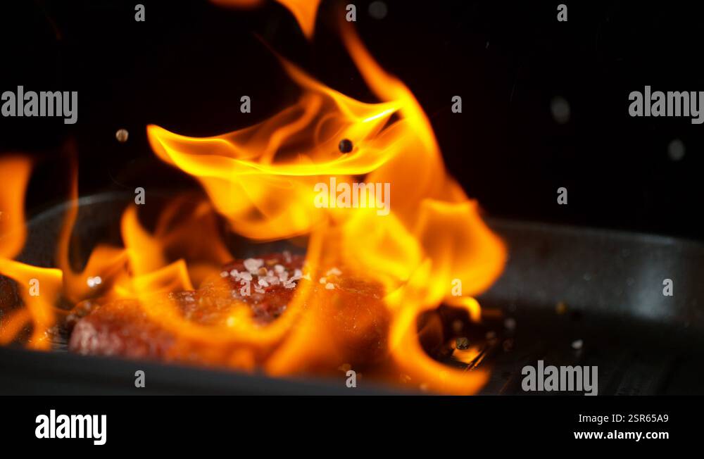 Super slow motion of falling beef minced hamburger meats into flames ...