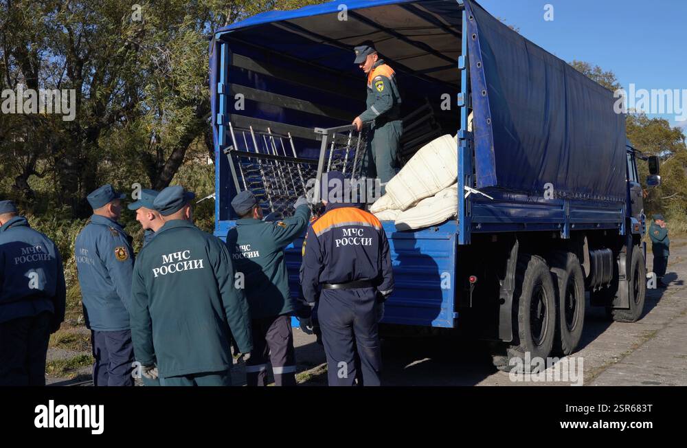 Group rescuers of Emercom of Russia unload truck with beds in tent ...