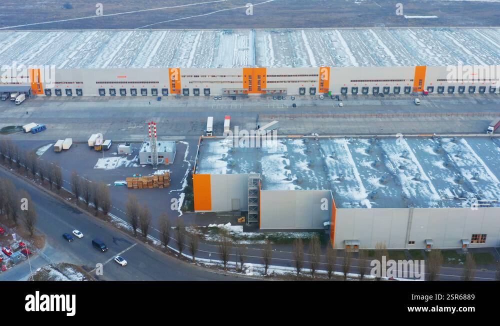 Aerial side view of the big warehouse logistics park with a semi ...