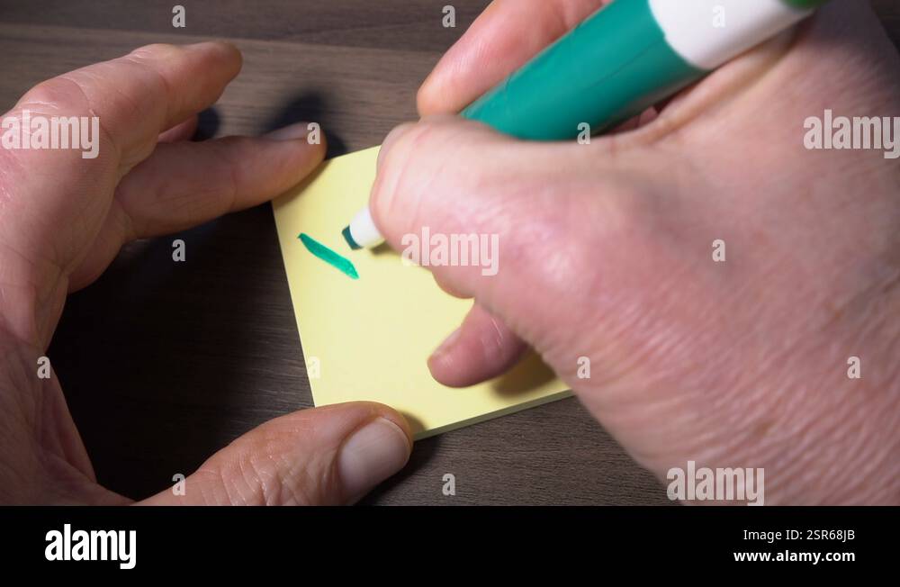 Slow motion – Writing ‘Yes’ followed by a tick, in green ink on a ...