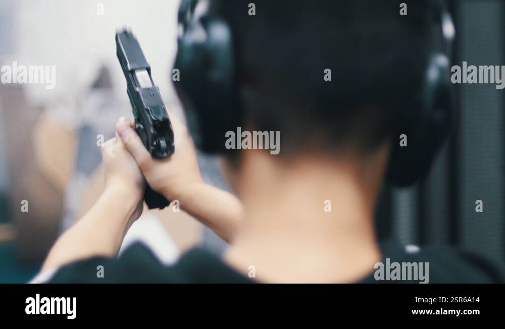 Shooting gallery. A young man aiming in a target using a gun. Shooting ...