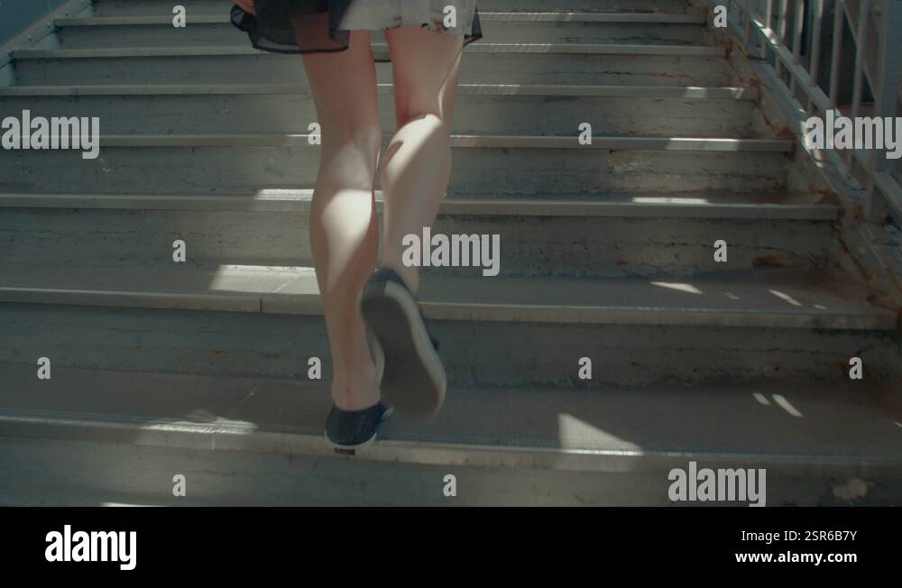 Camera follows a woman's feet as she walks upstairs on her way to catch ...