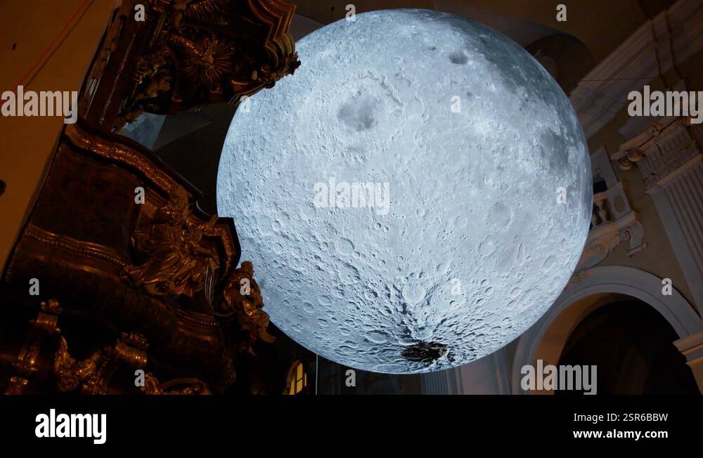 Spectacular full moon light installation suspended from a church ...