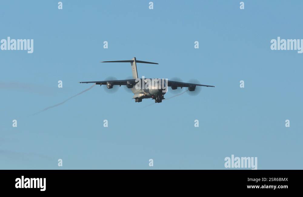 Military Airbus A400M Atlas propeller airplane passing overhead panning ...