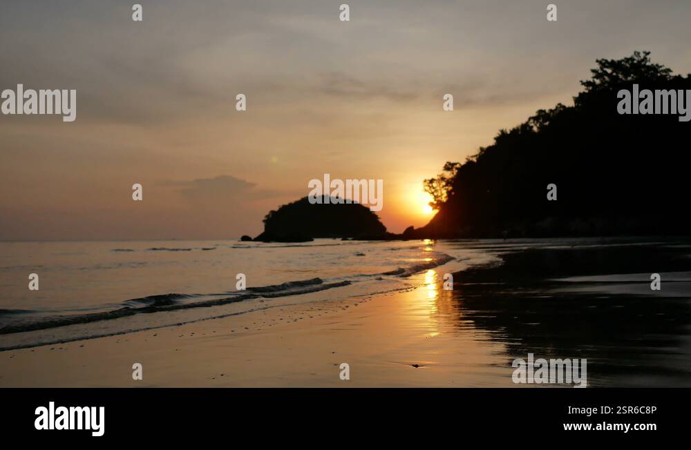 sea water wave hit sand beach with sunlight , silhouette tree mountain ...