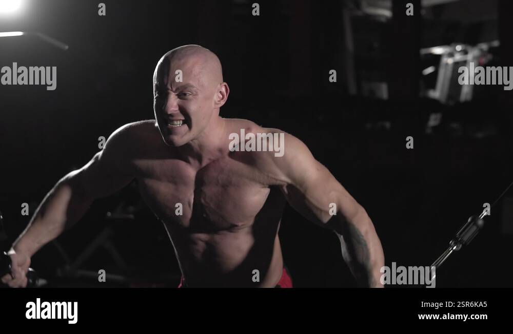 Bodybuilder training chest muscles using cable cross over machine for ...