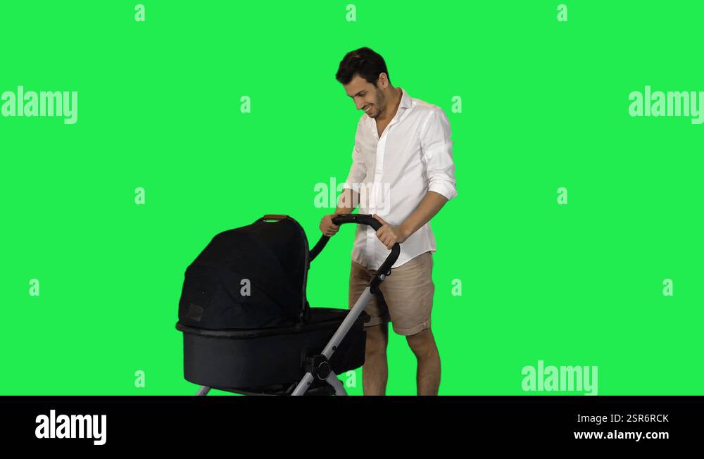 Relaxed dad pushing a stroller, smiling over a green screen Stock Video ...