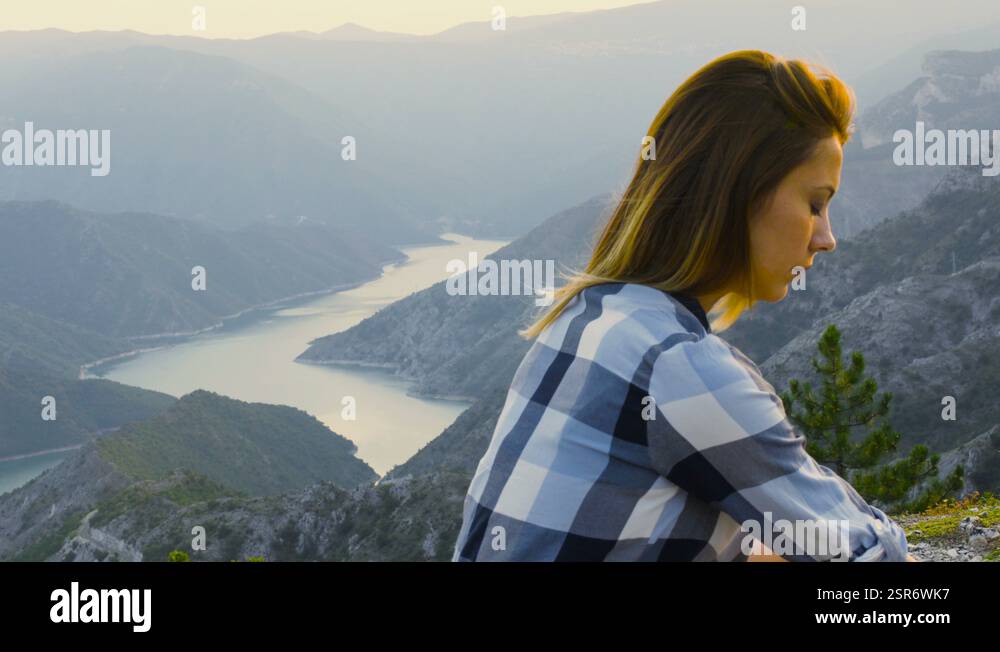 beautiful girl enjoying the view of a river lake and taking selfy ...
