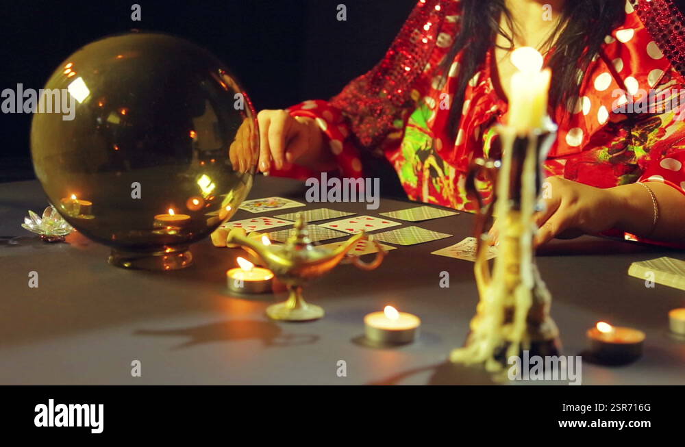A gypsy in a fortune-telling saloon by candlelight lays out cards for ...