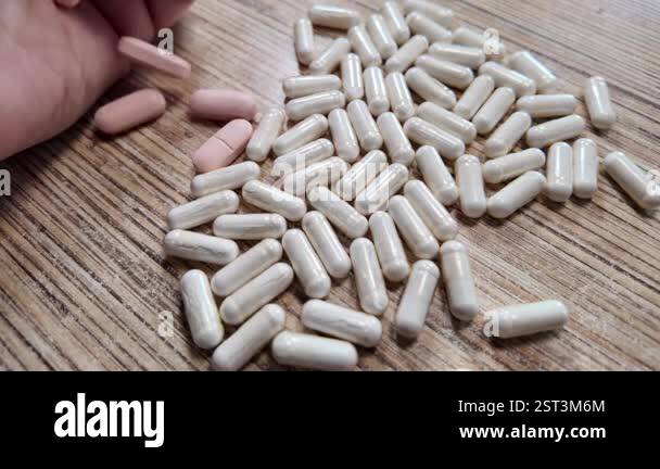 Different pills slowmotion. Colored pills of different shapes fall down ...