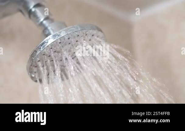 Water cascades down from a shiny shower head in a relaxing space Stock ...