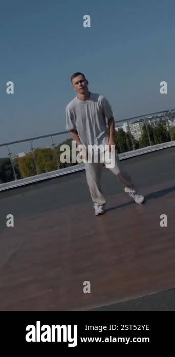 Vertical. The guy coolly dances breakdance on the roof of the house. A ...
