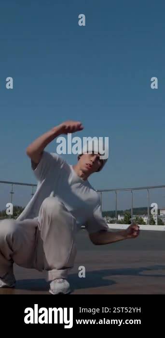 Vertical. The guy coolly dances breakdance on the roof of the house. A ...