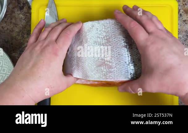 Cutting salmon fish with a knife for further cooking, preparing the ...