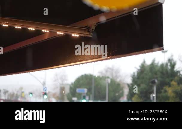 Raindrops continuously fall from a black awning on a rainy day Stock ...