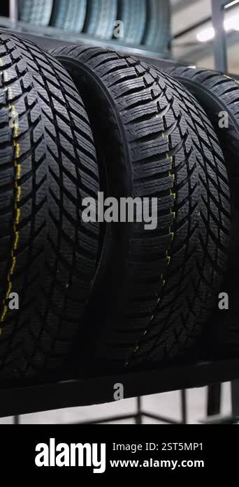 Detailed view of studless winter tires with deep tread and yellow guide ...