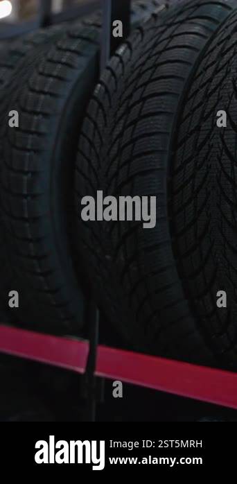 A detailed close-up of black car tires with deep tread patterns neatly ...