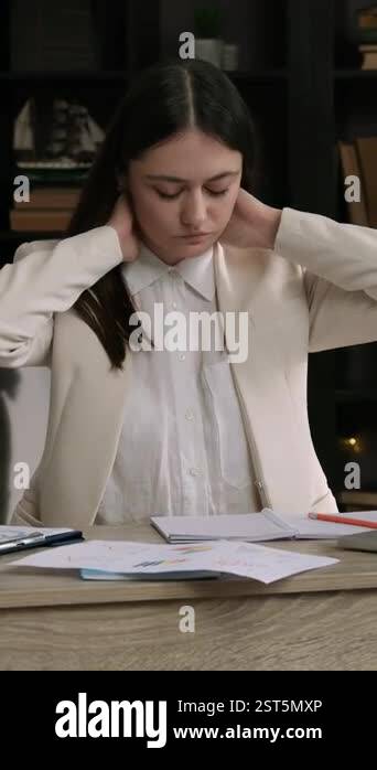 Young businesswoman massages neck feeling painful symptoms at workplace ...