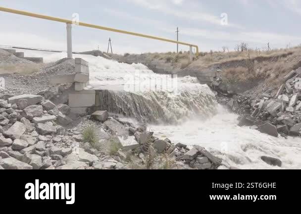 Splashing White Water Cascading Over a Waterfall Edge of concrete water ...