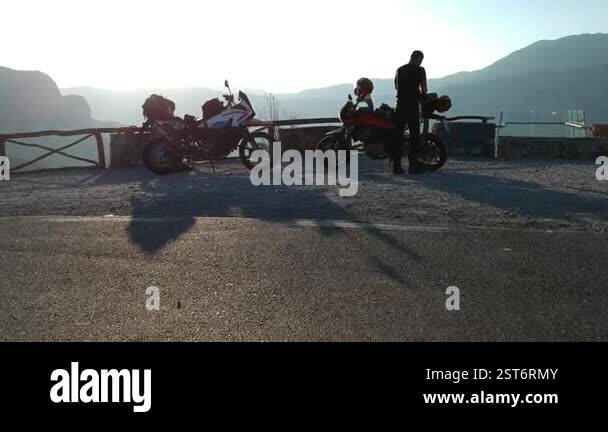 Flyby over two adventure motorcycles parked on a rapsh curve on famous ...
