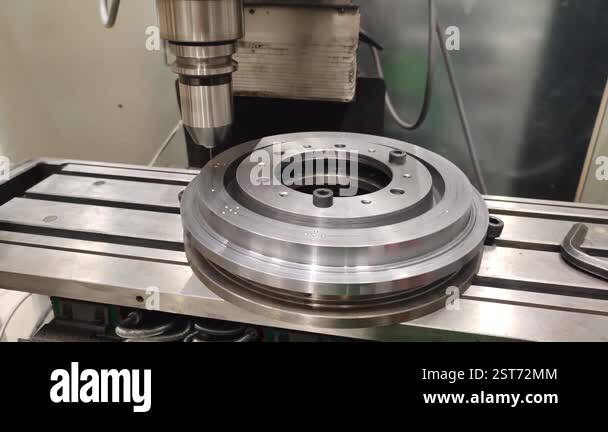 A CNC machine milling a metal disc with precision. The setup includes a ...