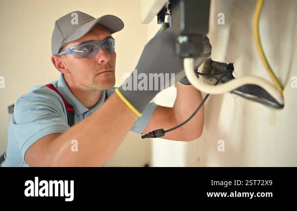 A skilled technician focuses on an solarelectrical installation process ...