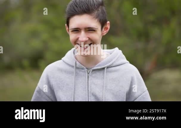 Cheerful playful teenage boy puffing cheeks with air and blowing it out ...