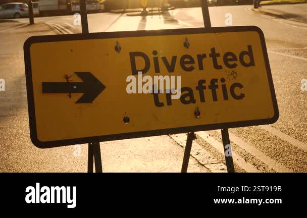Detour sign standing on sunlit road. Highway sign contour in morning ...