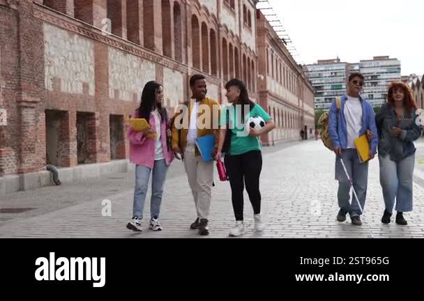 Diverse group of university students walking together, with a blind ...