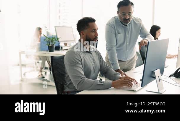 Senior Indian mentor checking work progress of African American intern ...
