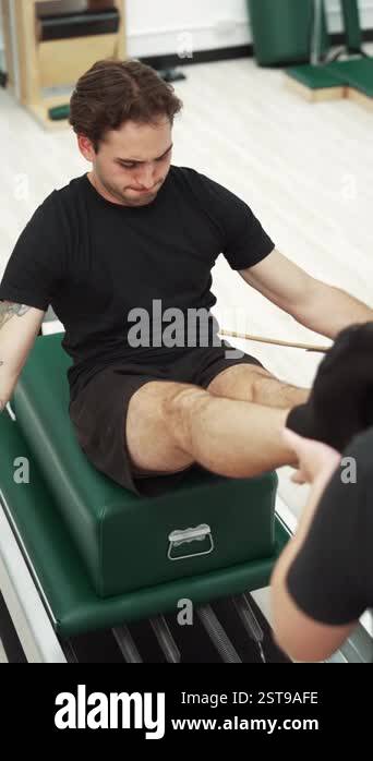 Man practicing seated arm pull exercise on pilates reformer to improve ...
