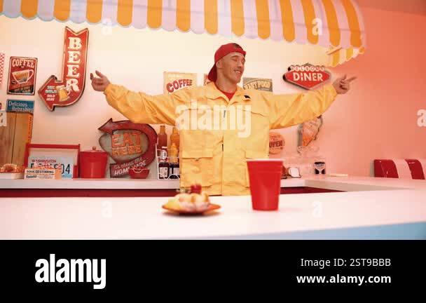 Happy caucasian restaurant worker dancing and putting food to table ...