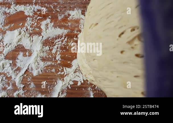 A highly detailed close-up of fermented dough being lifted, revealing ...