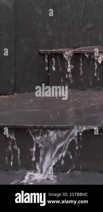Dark wet stairs with water rushing over them, creating cascading ...