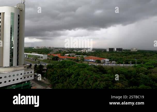 Dark storm clouds slowly take over the sky above the modern cityscape ...