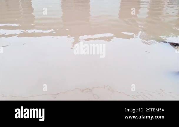A pool of rippling flood water with a white and cloudy water texture ...