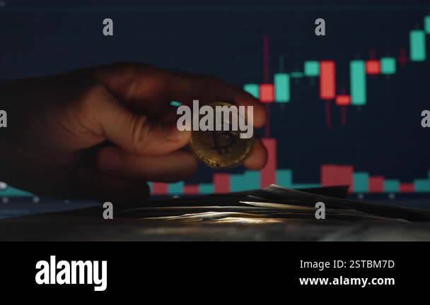 Hand Holding a Bitcoin Coin with Trading Chart in Background Showing ...